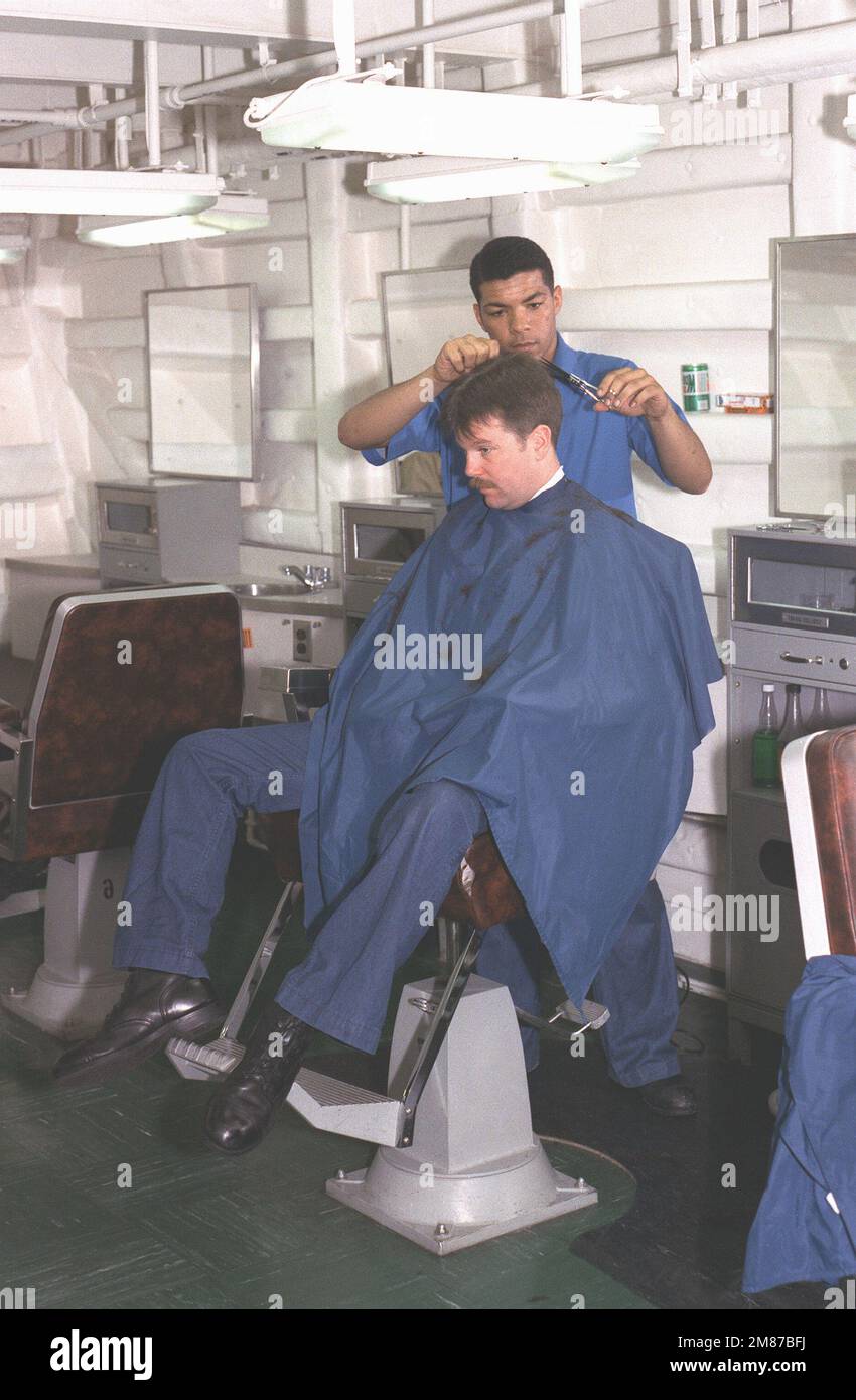 A sailor gives a haircut in the barber shop aboard the nuclear-powered ...