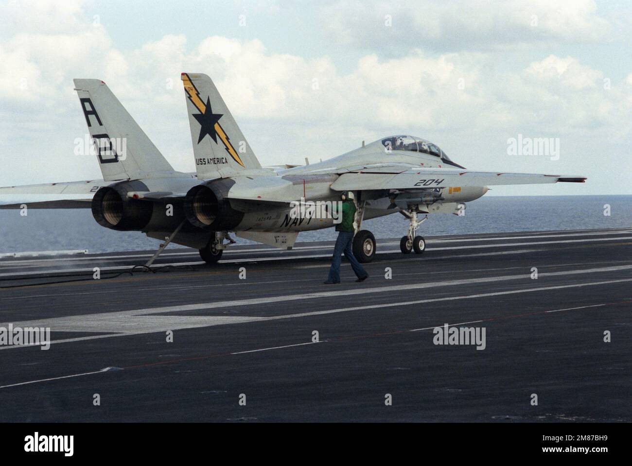 A flight deck crewman signals the pilot of a Fighter Squadron 33 (VF-33 ...