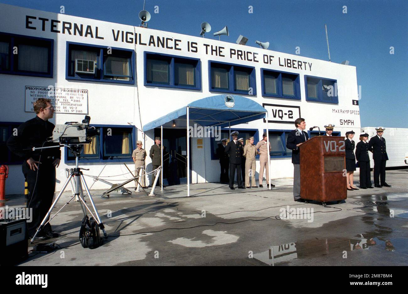 A sailor videotapes Secretary of the Navy John F. Lehman Jr. as he ...