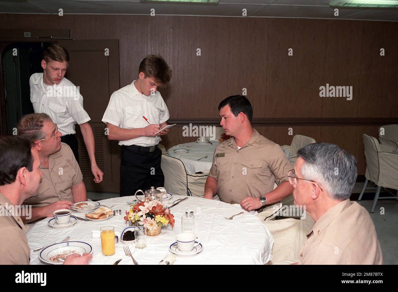 A messman takes meal orders from officers in the wardroom aboard the ...
