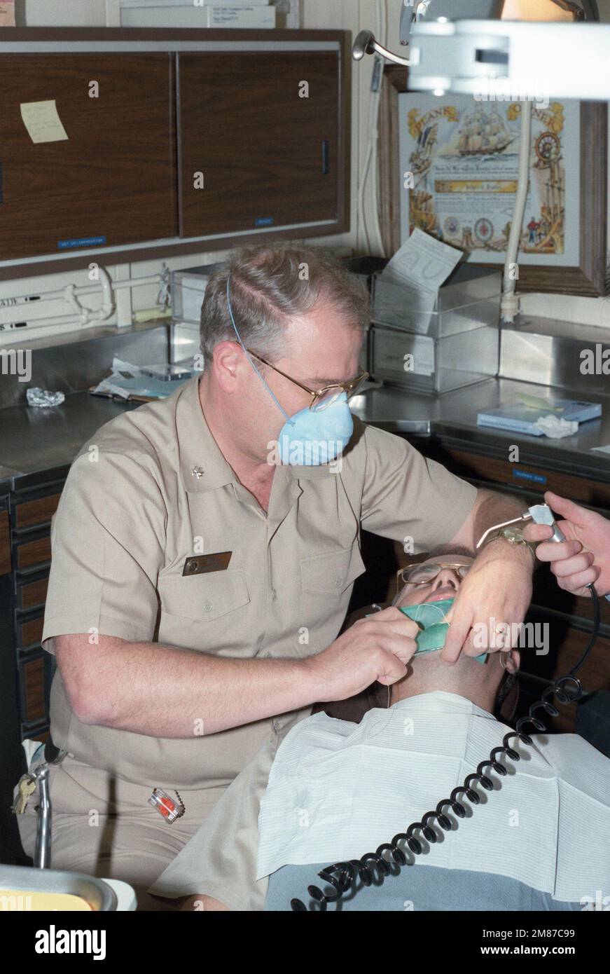 A Navy dentist works on a sailor's teeth aboard the nuclear-powered ...