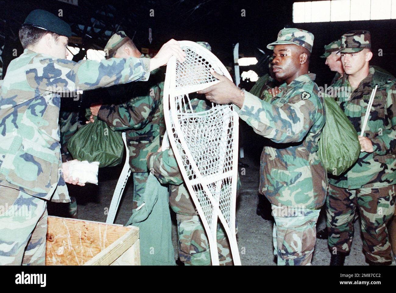 PFC Jerald Reese, Company C, 22nd Infantry, 25th Infantry Division, takes a pair of snowshoes ...