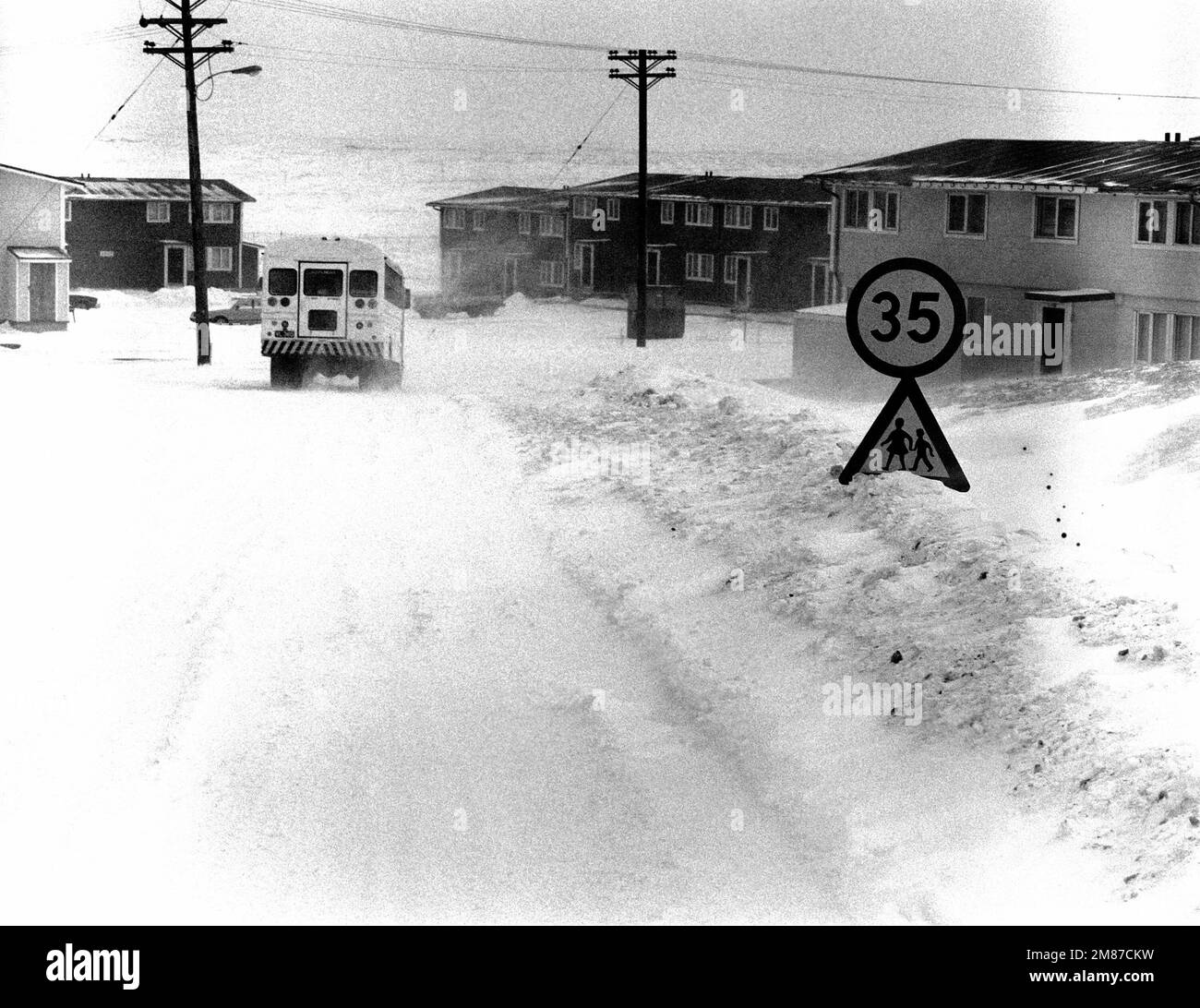 A base bus travels through snow at the Coral Sea housing area. Base ...