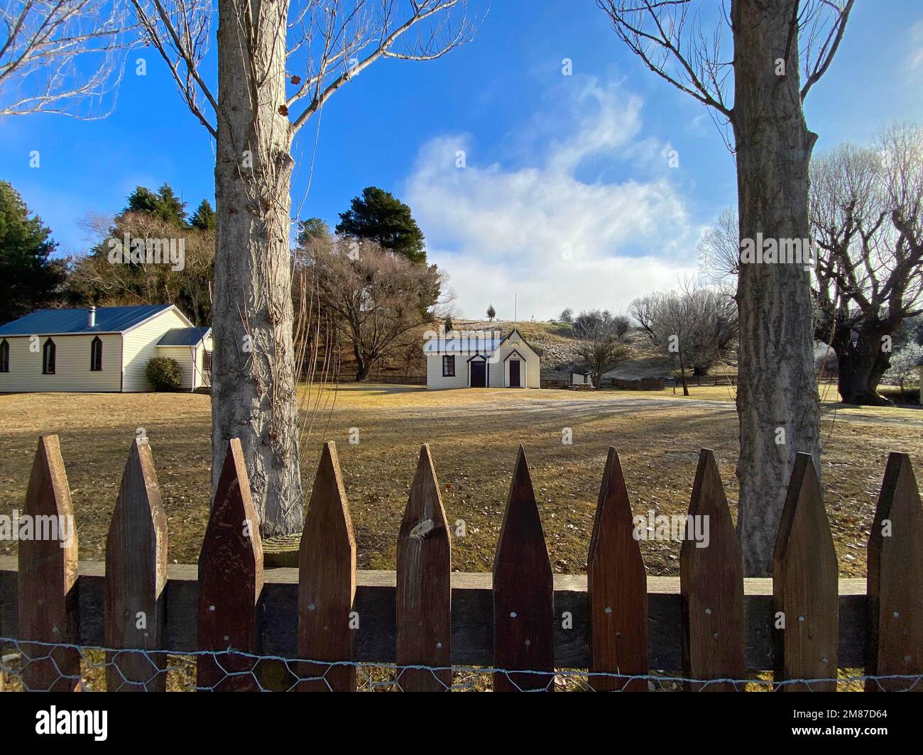 Cardrona village town hall with grass lawn and a picket fence viewed ...