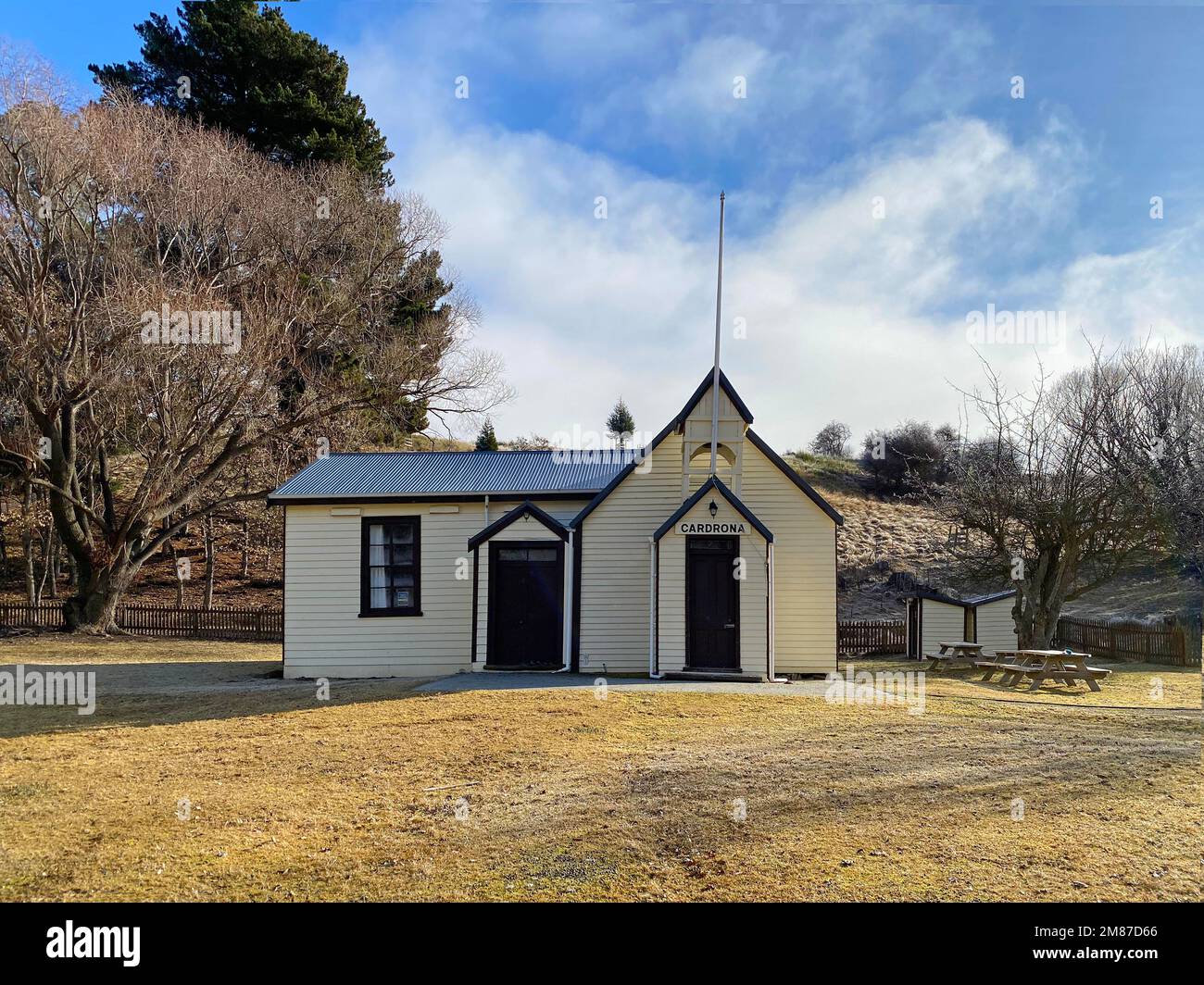 Cardrona village town hall with grass lawn and a picket fence viewed ...
