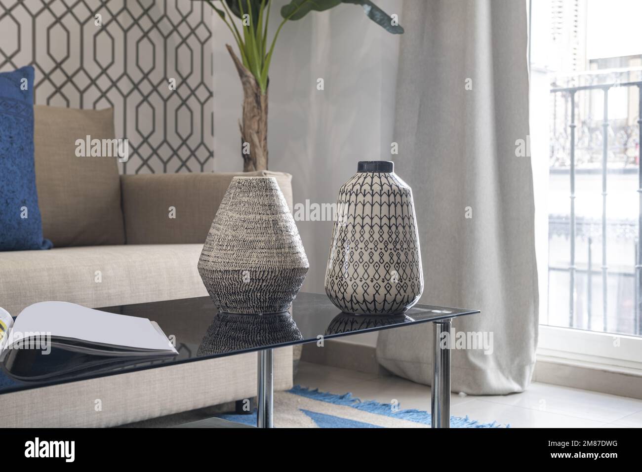 Glass coffee table with decorative vases in a living room of a vacation ...