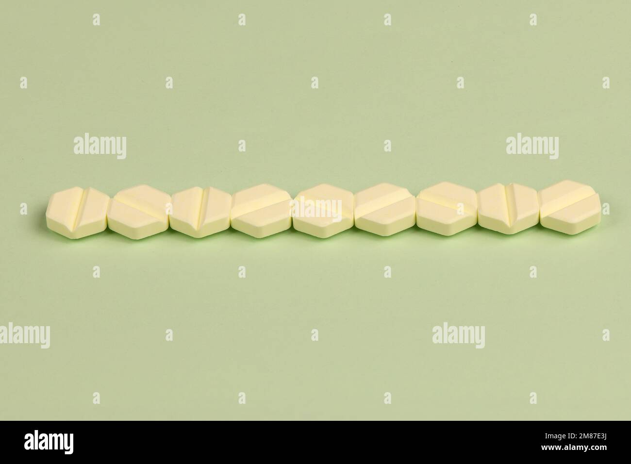 Hexagonal pills on light green background. Extreme closeup. High ...