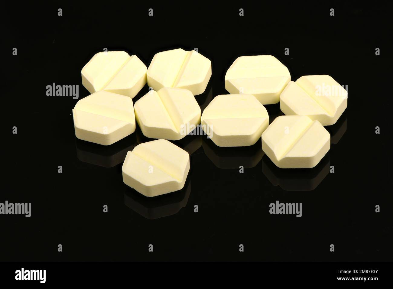 Hexagonal pills on light black acrylic background. Extreme closeup ...