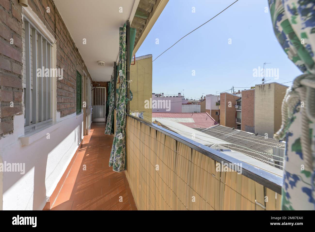 Narrow terrace balcony for access to homes with metal railing and green ...