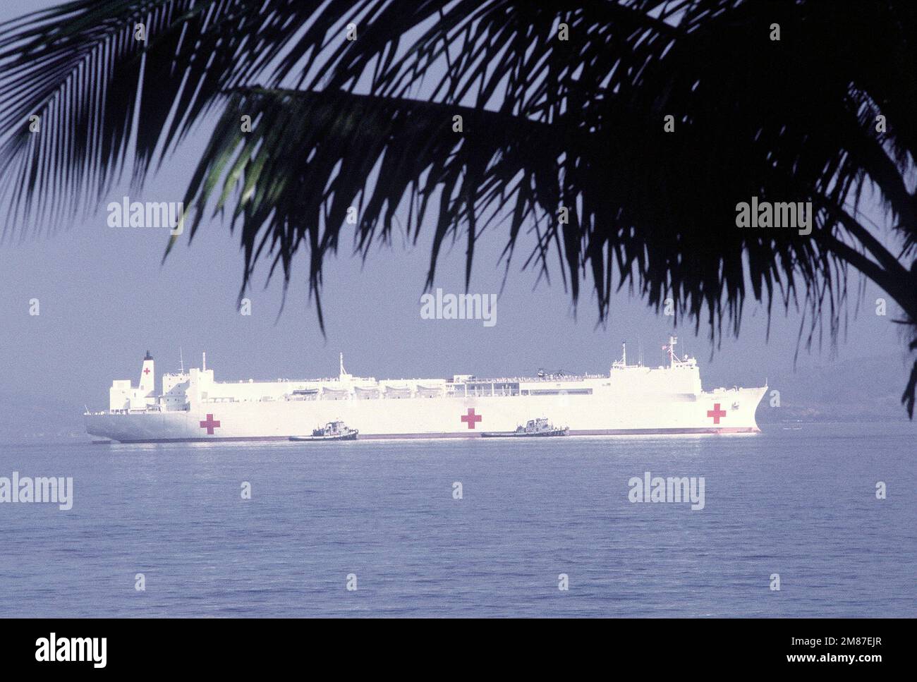 Two large harbor tugs (YTBs) stand by to position the hospital ship ...
