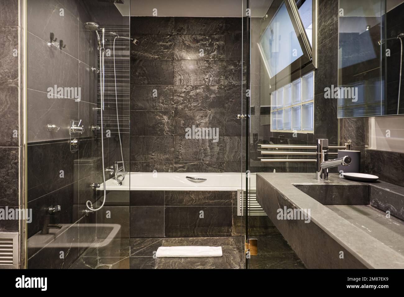 Bathroom in gray and black tones with one-piece gray marble sink ...