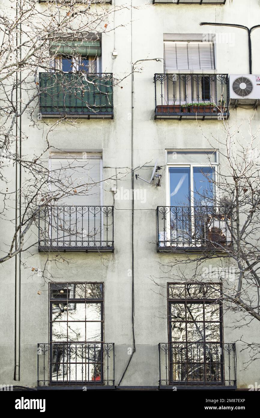 Simple facade of a building with French windows in the lower part and ...
