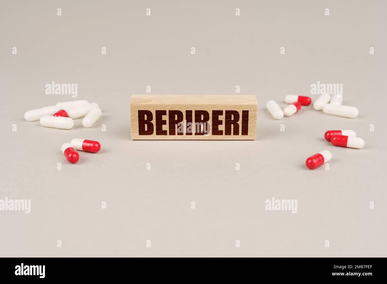 Medical concept. On a gray surface are tablets, capsules and a wooden ...