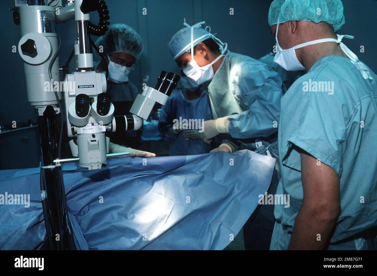 An ophthalmologist and medical technicians prepare to remove a cataract ...
