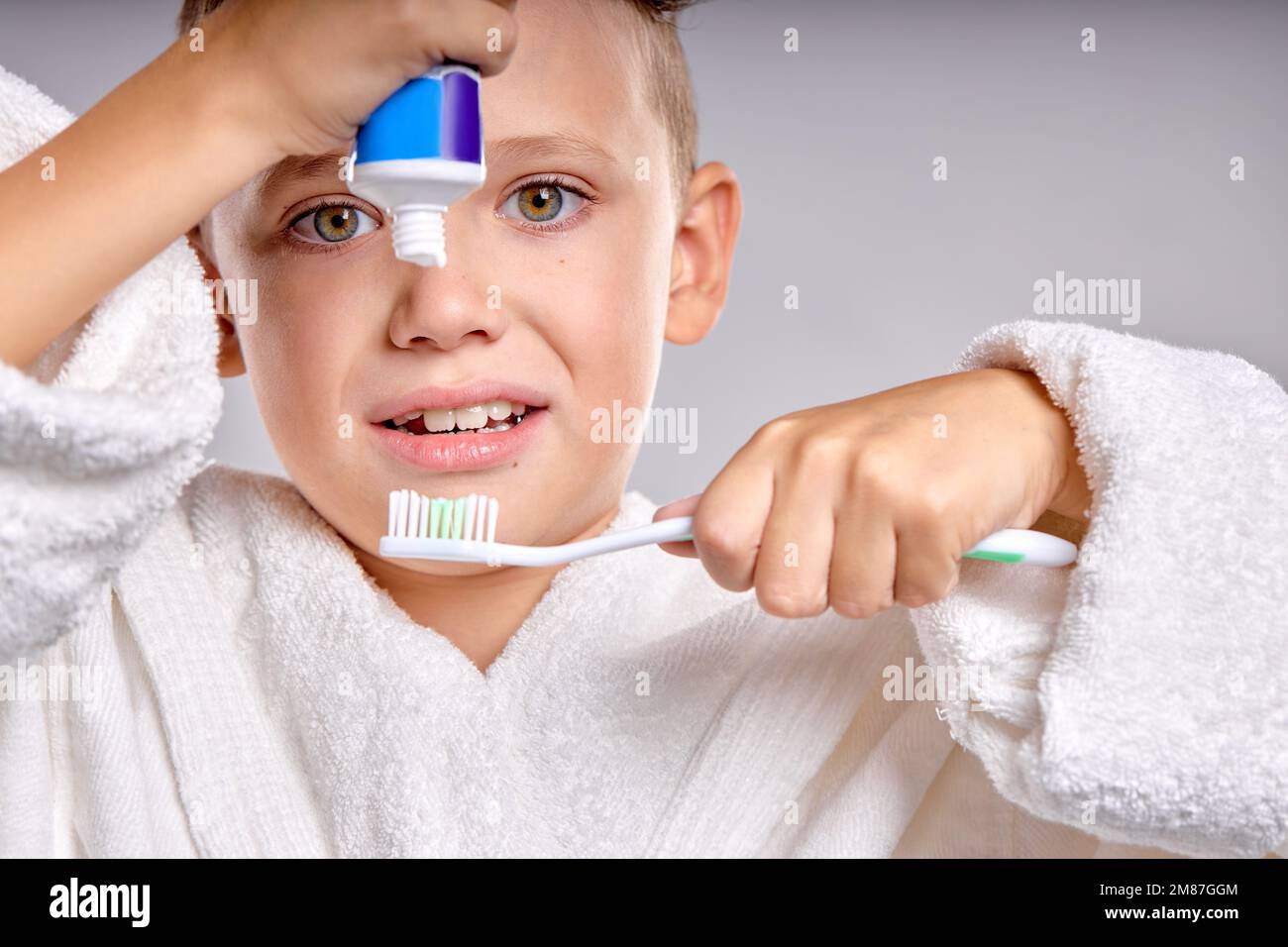 caucasian Child going to brush teeth. Kid applying paste on tooth brush ...