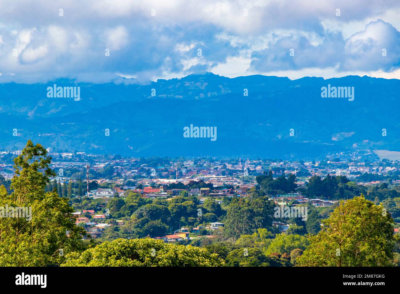 Beautiful mountain landscape and city panorama with forest trees clouds ...