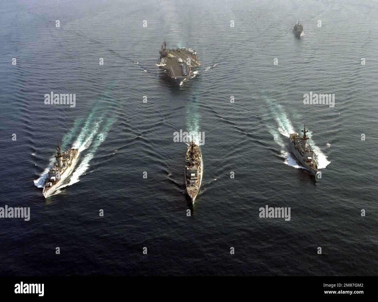 An aerial bow view of various U.S. Navy ships of the aircraft carrier ...