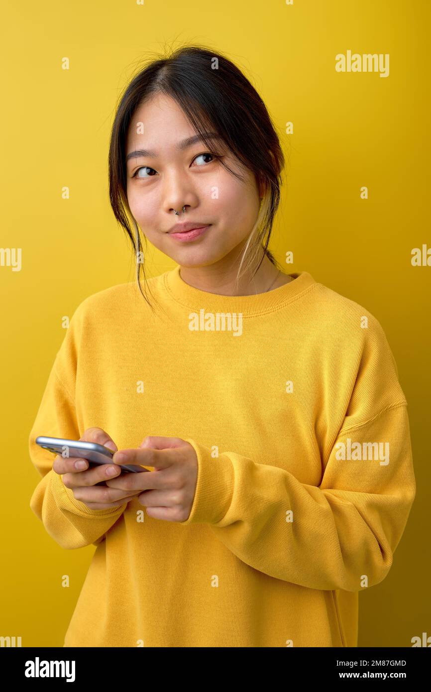 Photo of charming asian lady holding telephone in hands reading new ...