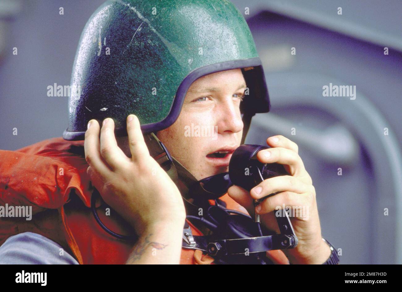 A crew member aboard the battleship USS NEW JERSEY (BB-62) communicates ...
