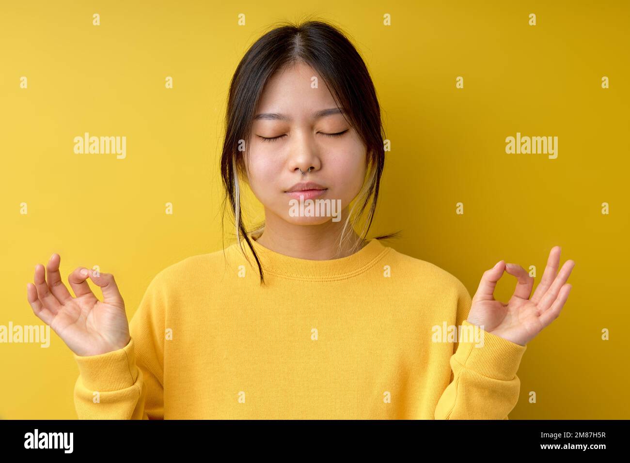 calm confident asian or chinese woman makes zen nirvana gesture ...