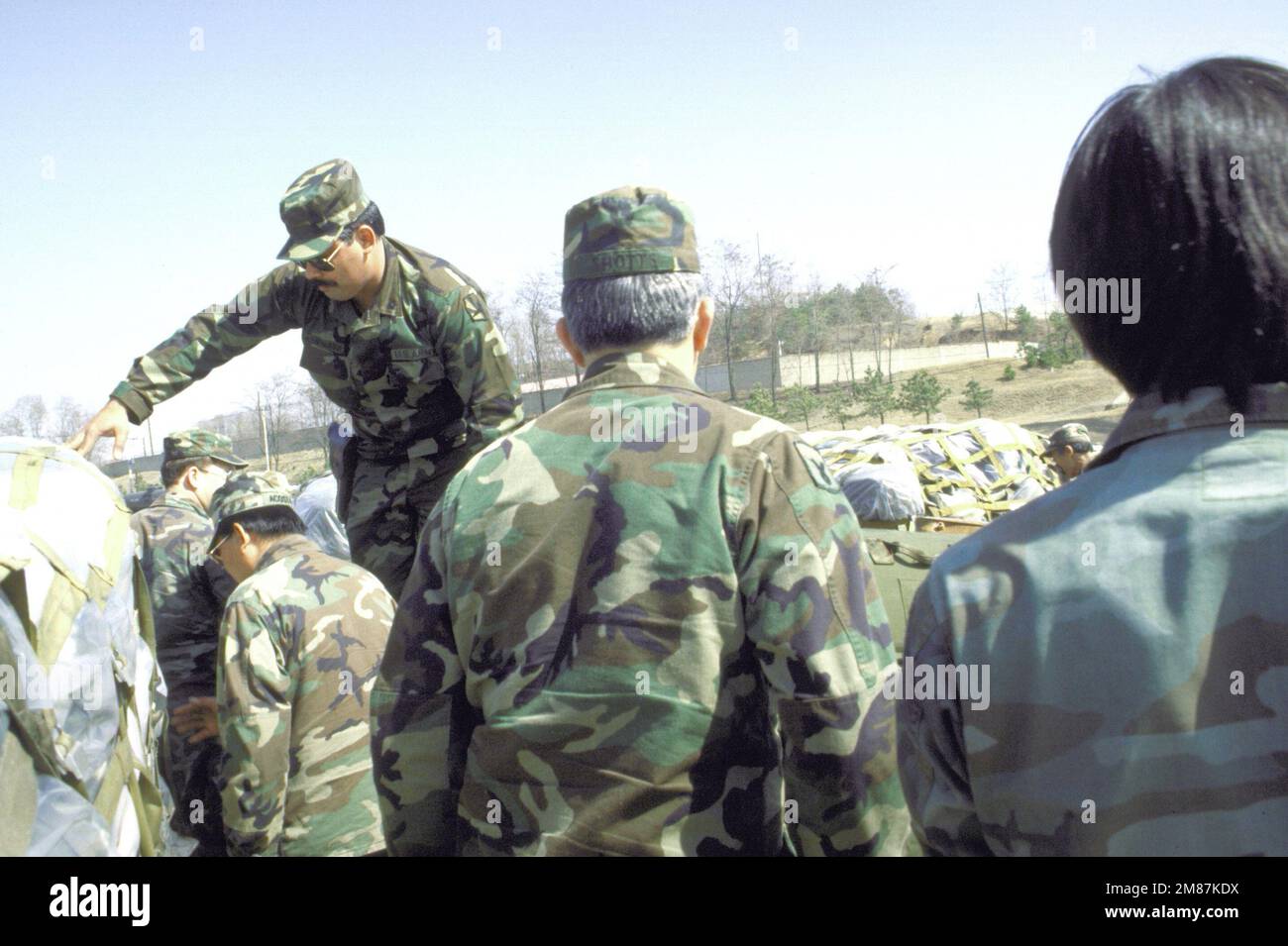 U.S. Army and Republic of Korea personnel unload a pallet of duffel ...