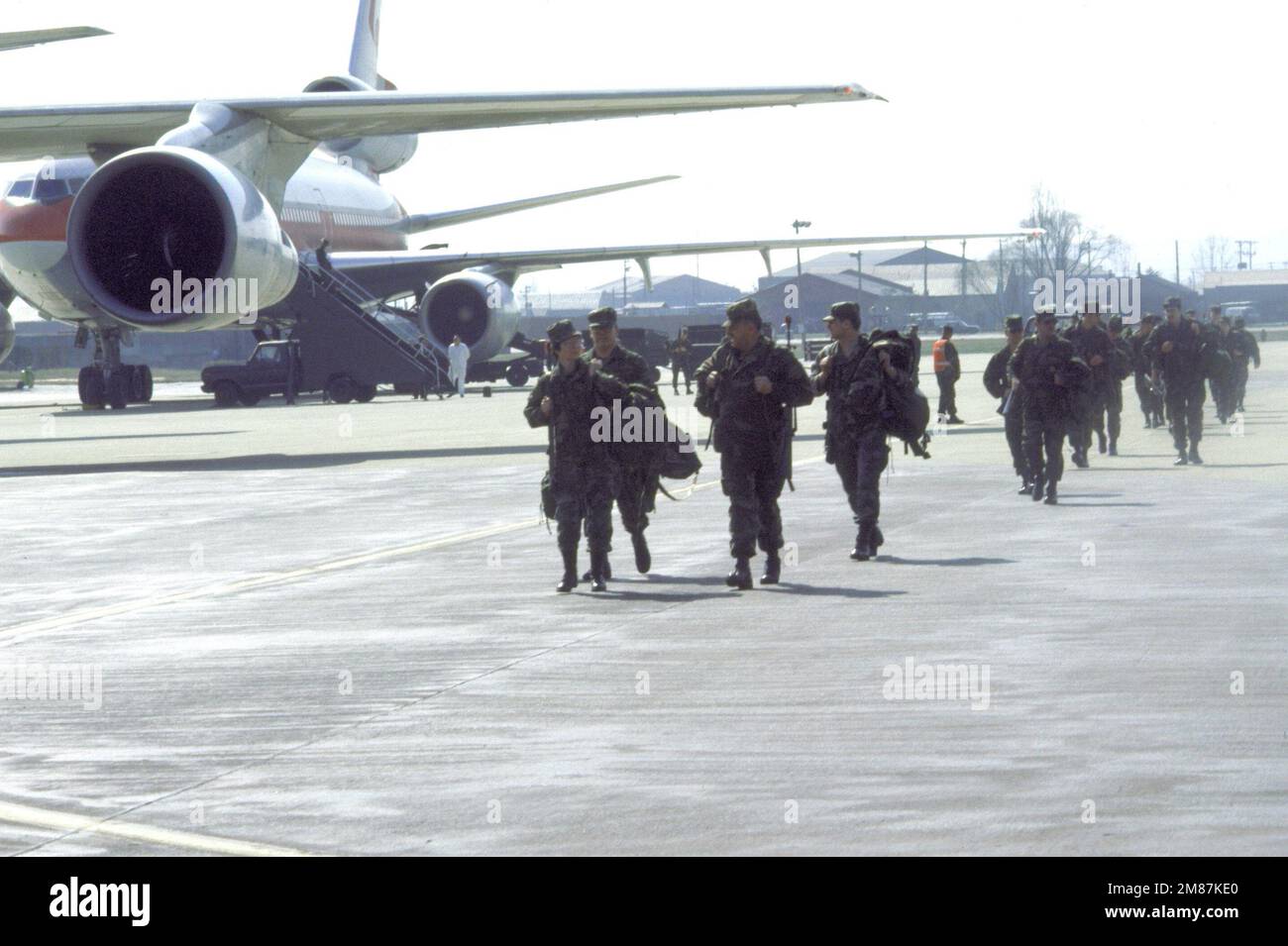 Military personnel walk off the flight line and head for their assembly ...