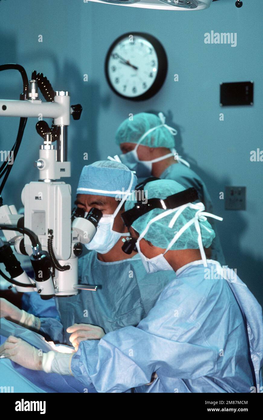An ophthalmologist and medical technicians prepare to remove a cataract ...