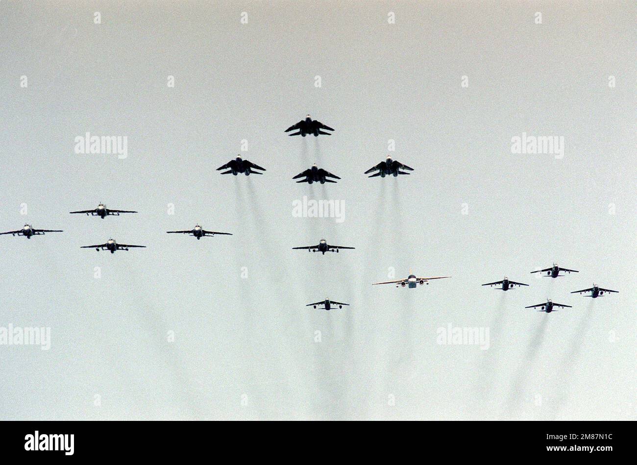 A group of aircraft fly in formation over the aircraft carrier USS ...