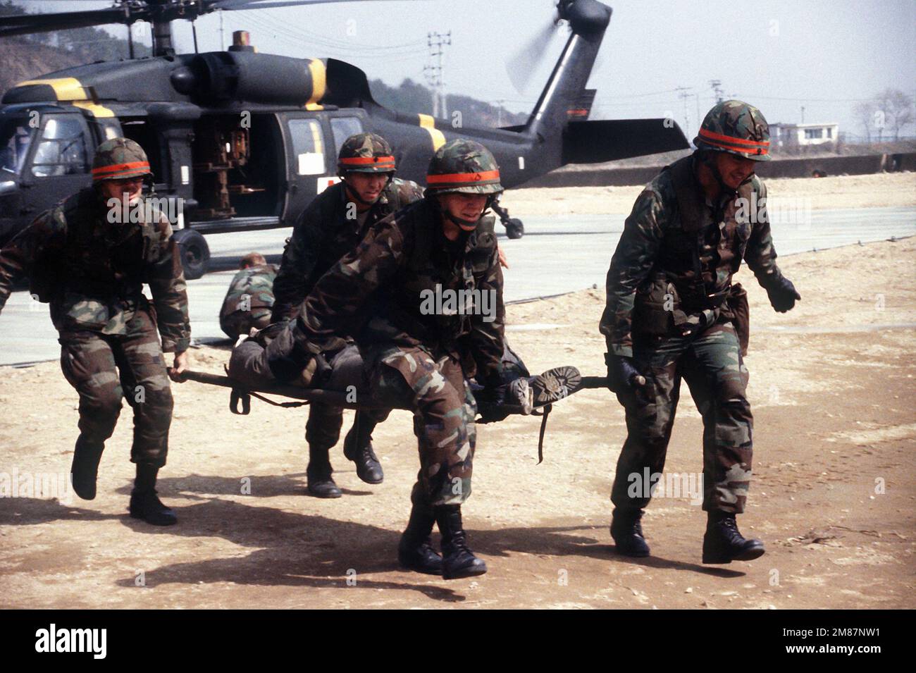Members of the 129th Evacuation Hospital rush a wounded soldier on a ...