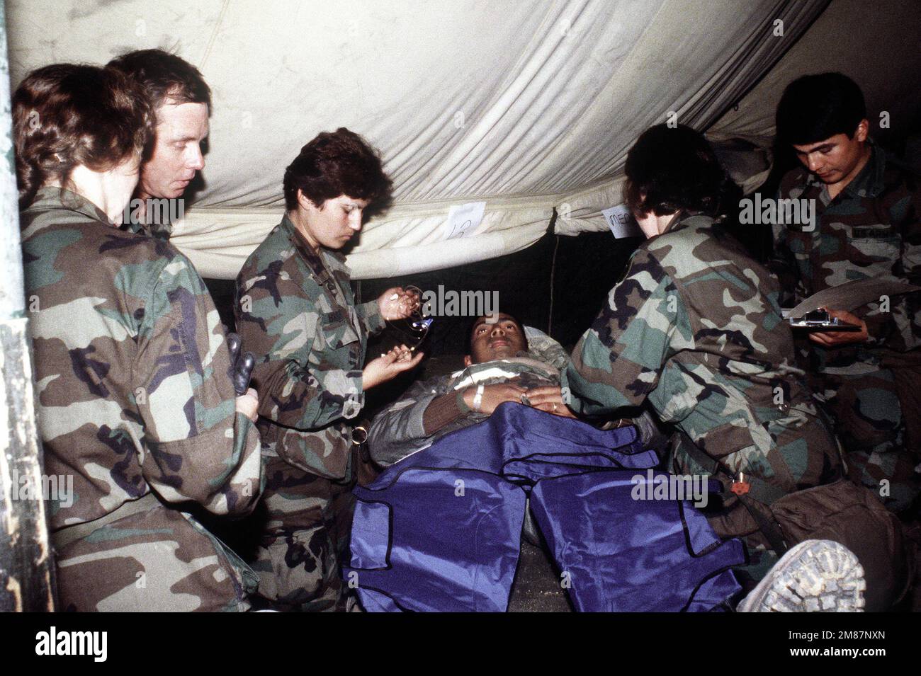 Members of the 129th Evacuation Hospital prepare a wounded soldier for ...