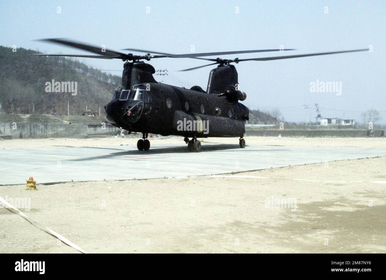 A CH-47 Chinook helicopter stands by on a temporary landing pad set up ...