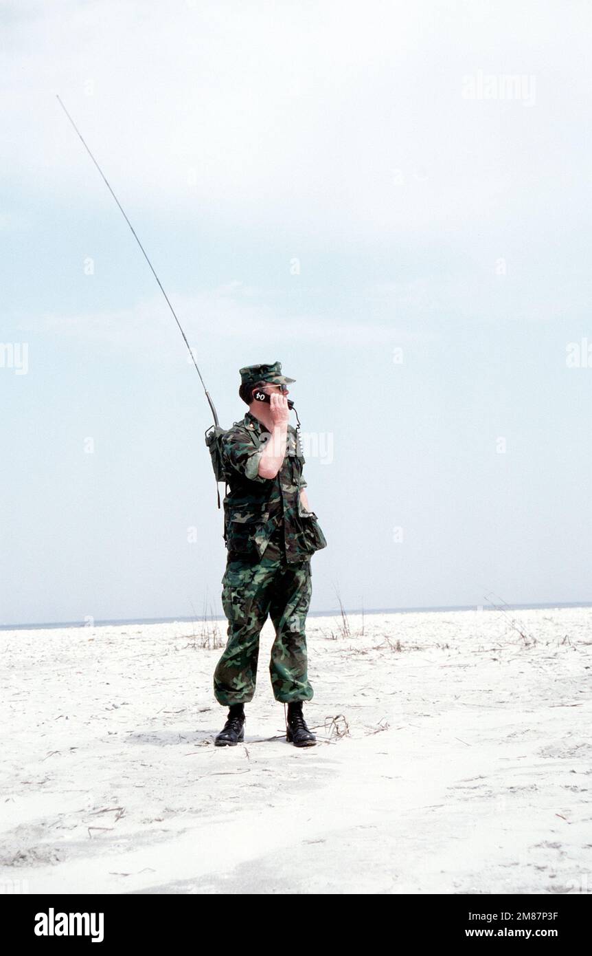 A Marine Reserve officer uses a field radio to coordinate helicopter ...