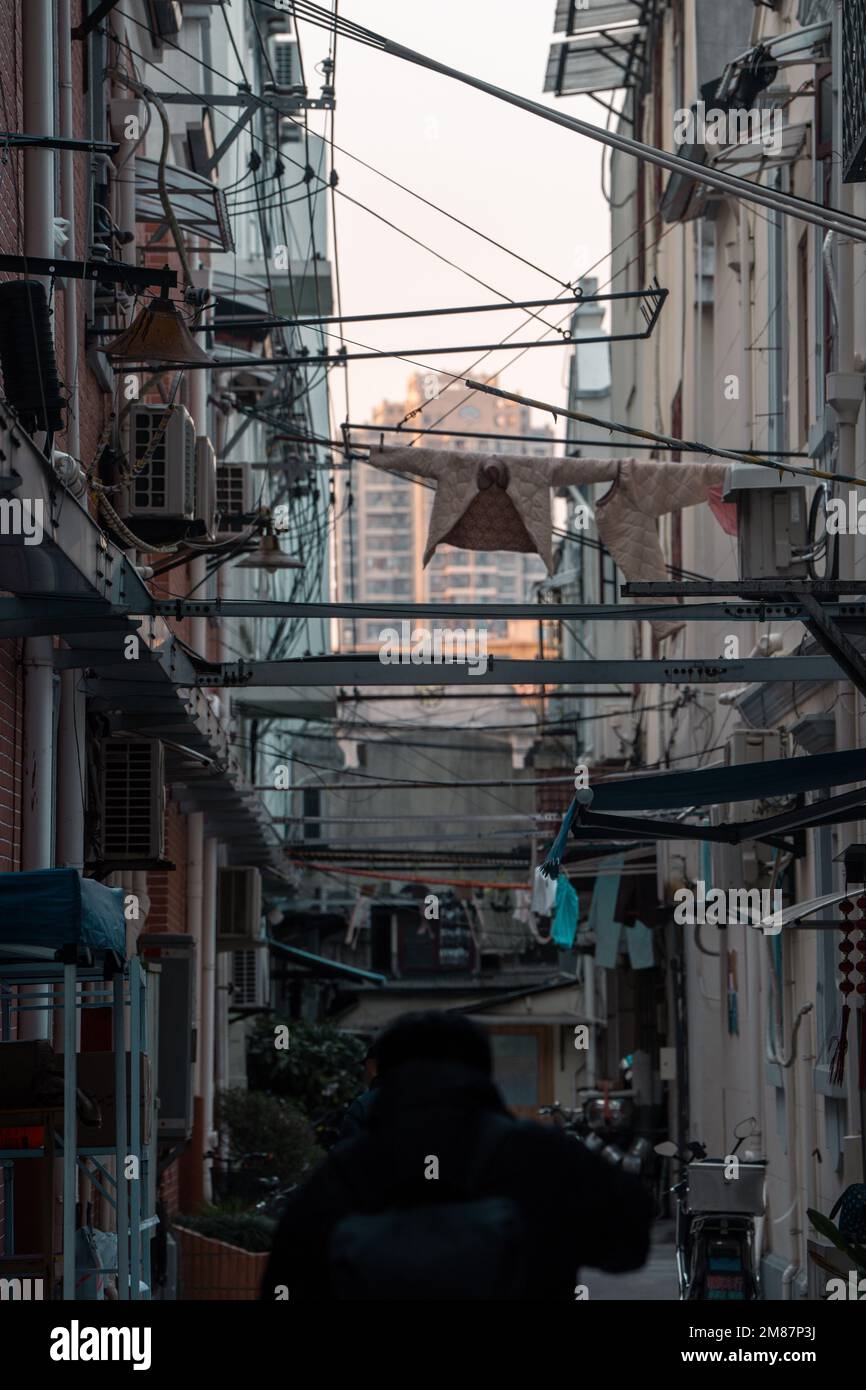An alley with crowded buildings on each side and clothing lines hanging ...