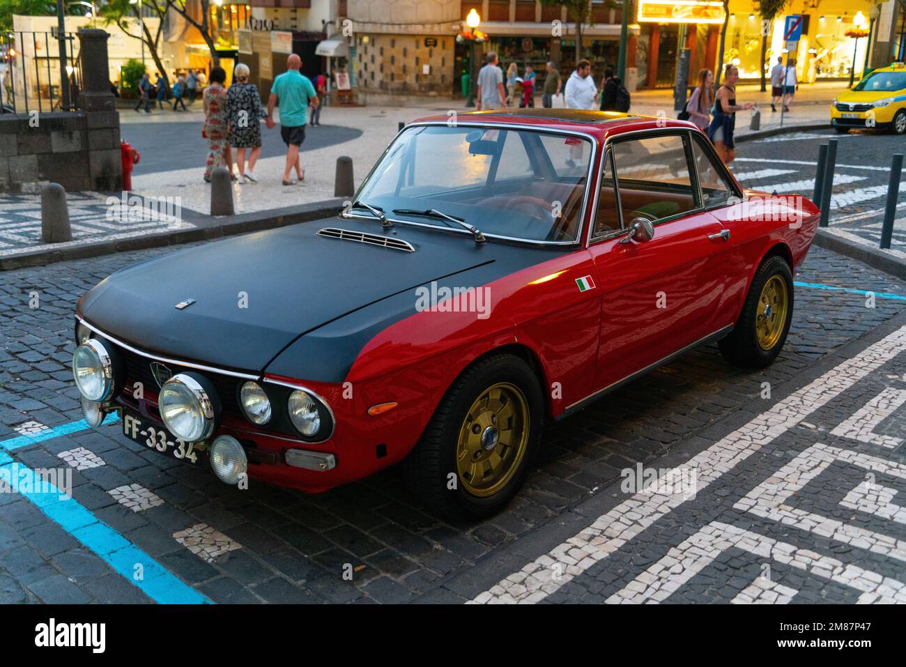 A retro red and black Lancia Fulvia car parked on a street in Madeira ...
