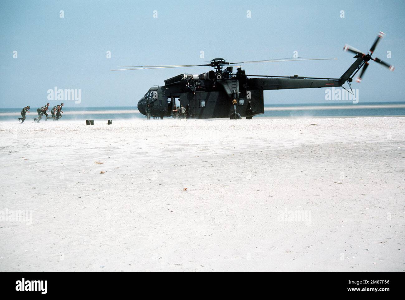 Marine reservists charge a CH-54 Tahre helicopter to unload supplies ...