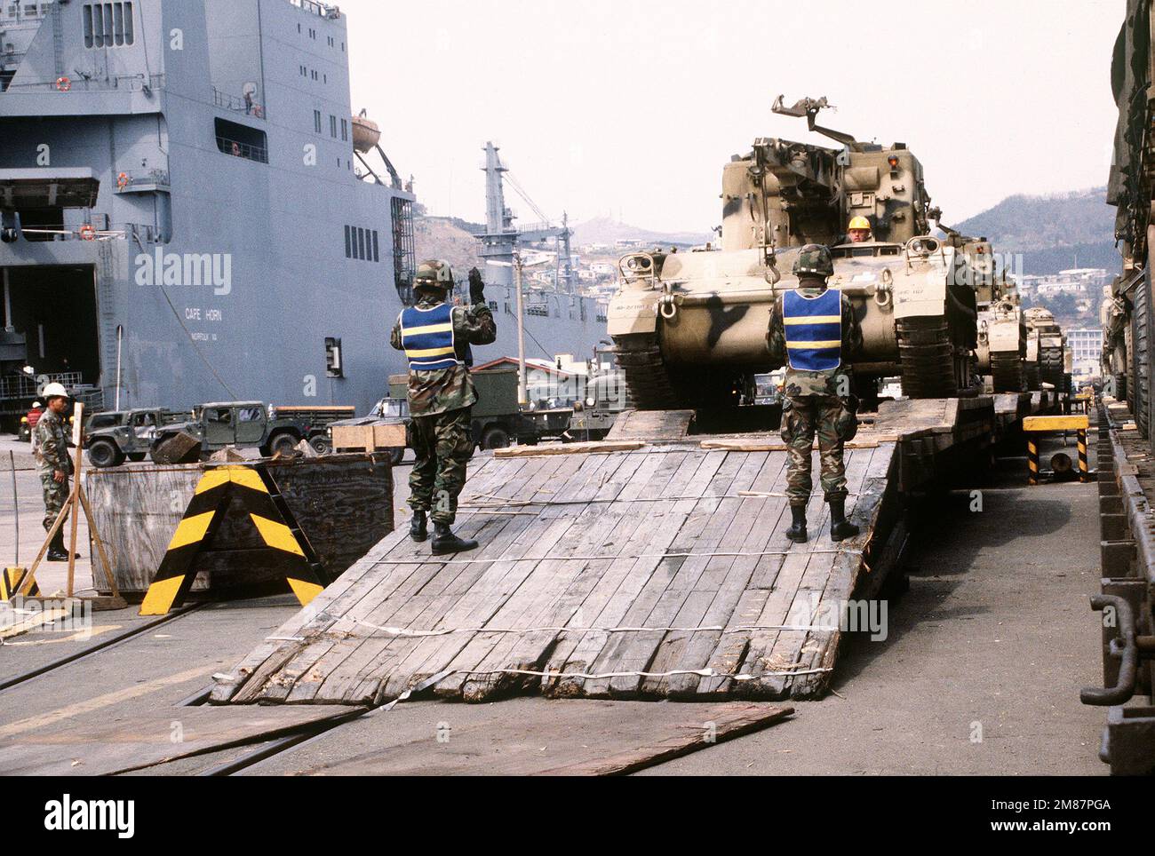 An M-578 light armored recovery vehicle is driven off a railroad ...