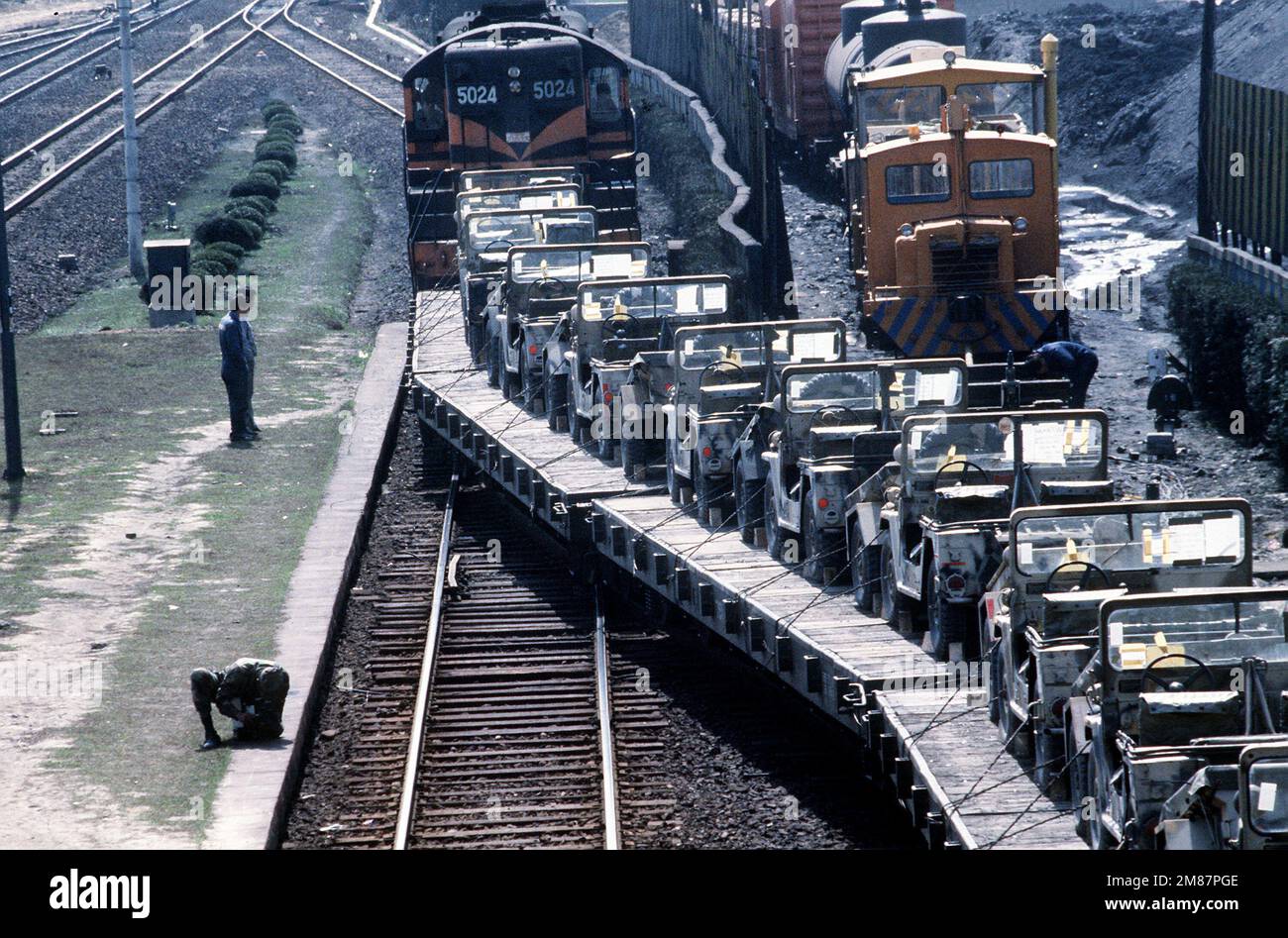 A train loaded with M-151 light utility vehicles departs for the port ...