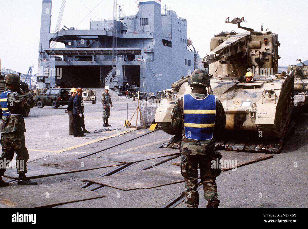 An M-578 light armored recovery vehicle is driven off a railroad ...