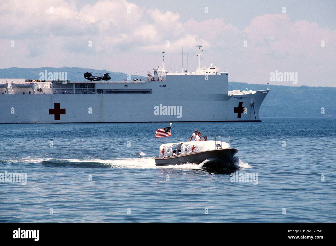 A motor launch from the hospital ship USNS MERCY (T-AH-19), background ...