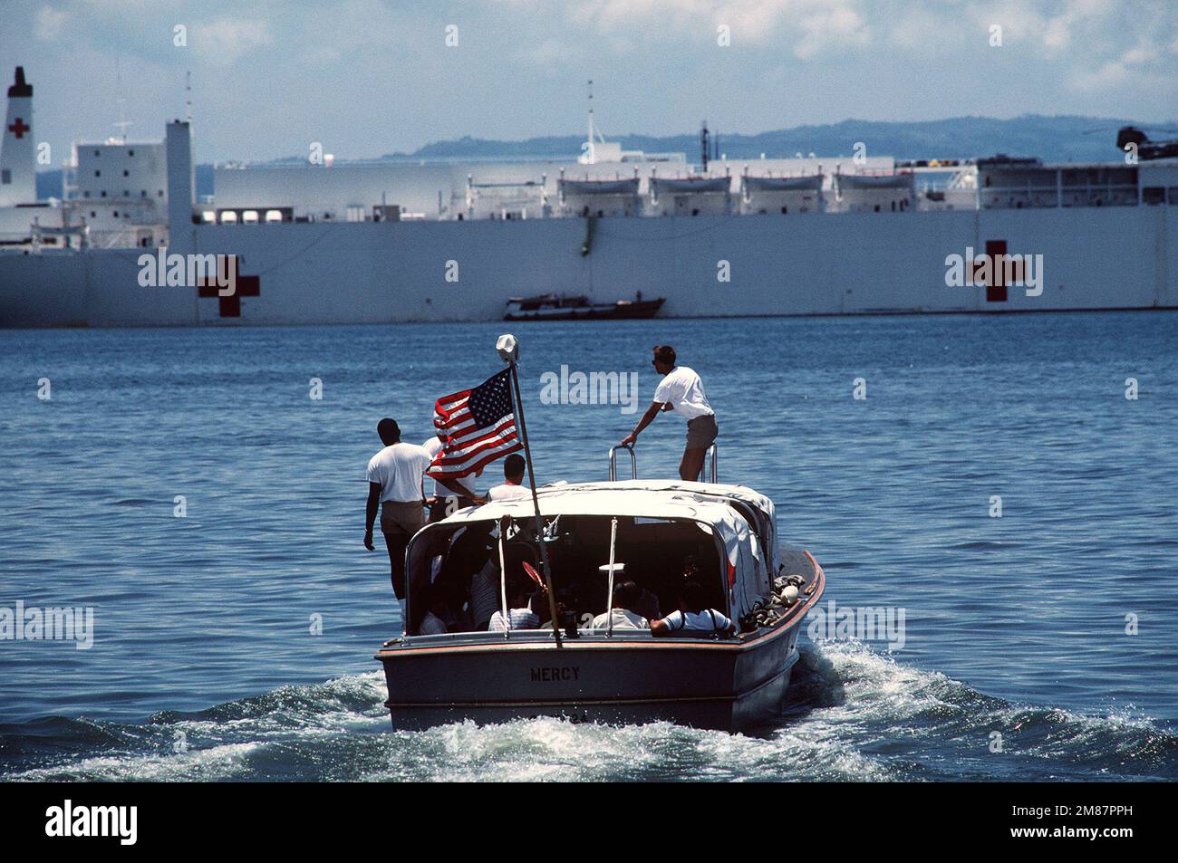A motor launch from the hospital ship USNS MERCY (T-AH-19), background ...