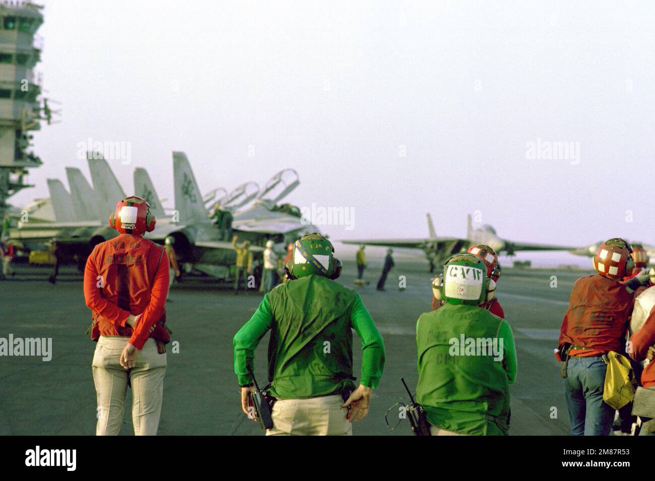 Flight deck crew members stand by during flight operations aboard the ...