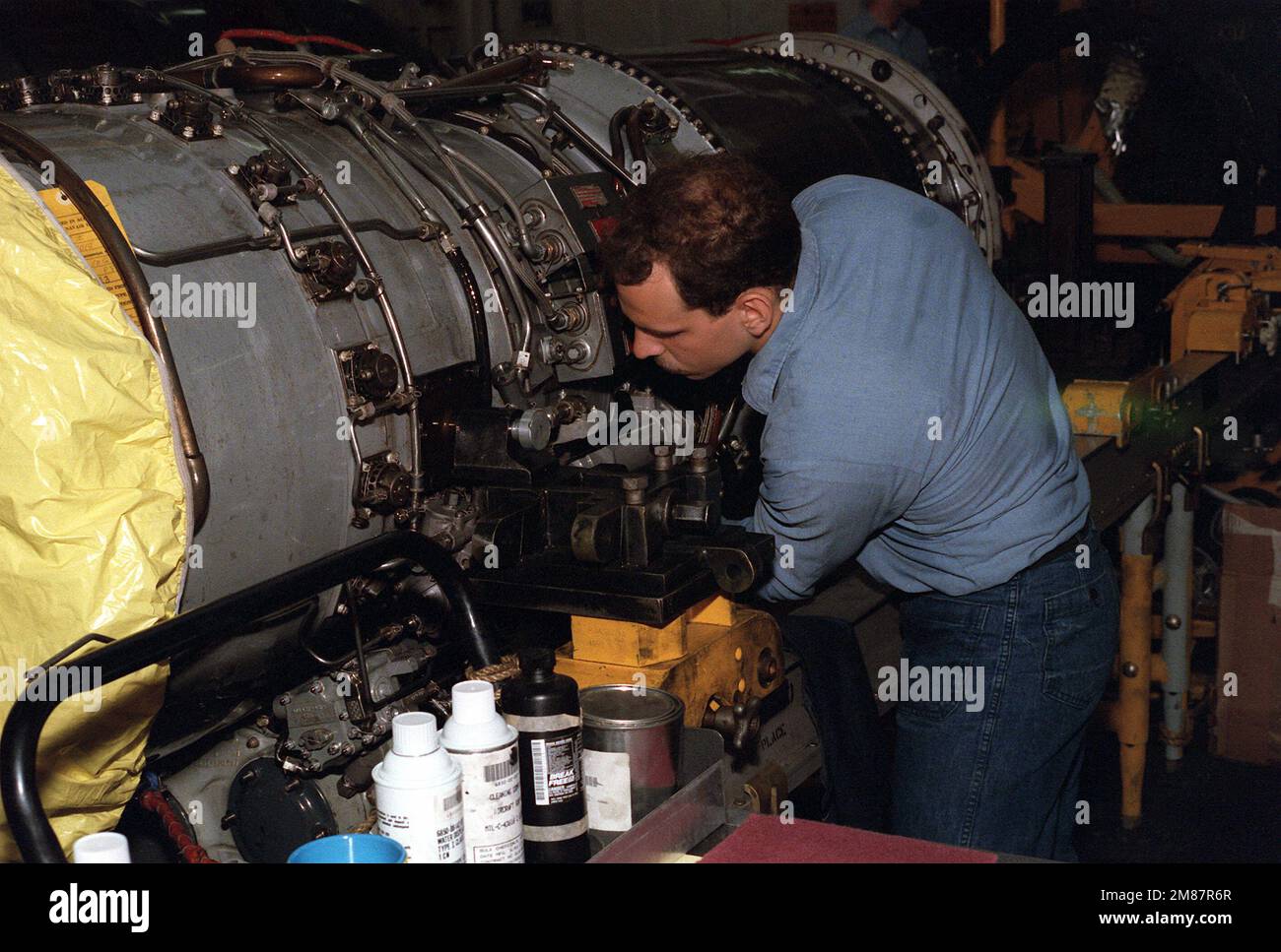 A crew member repairs a jet engine in the Aircraft Intermediate ...