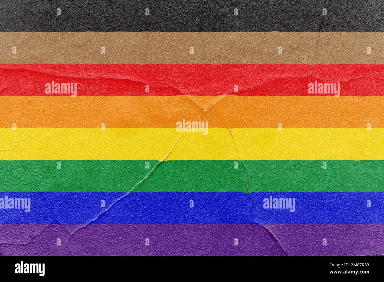 Pride rainbow flag with black and brown stripes painted on cracked ...