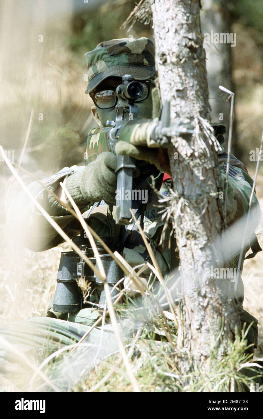 A camouflaged member of the 51st Security Police Squadron aims his M-16 ...