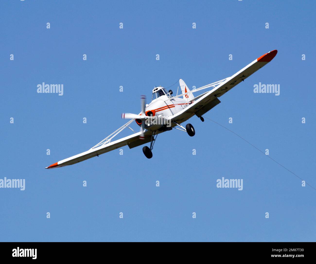 A Piper Pawnee glider tug on a short high approach trailing a loose tow ...