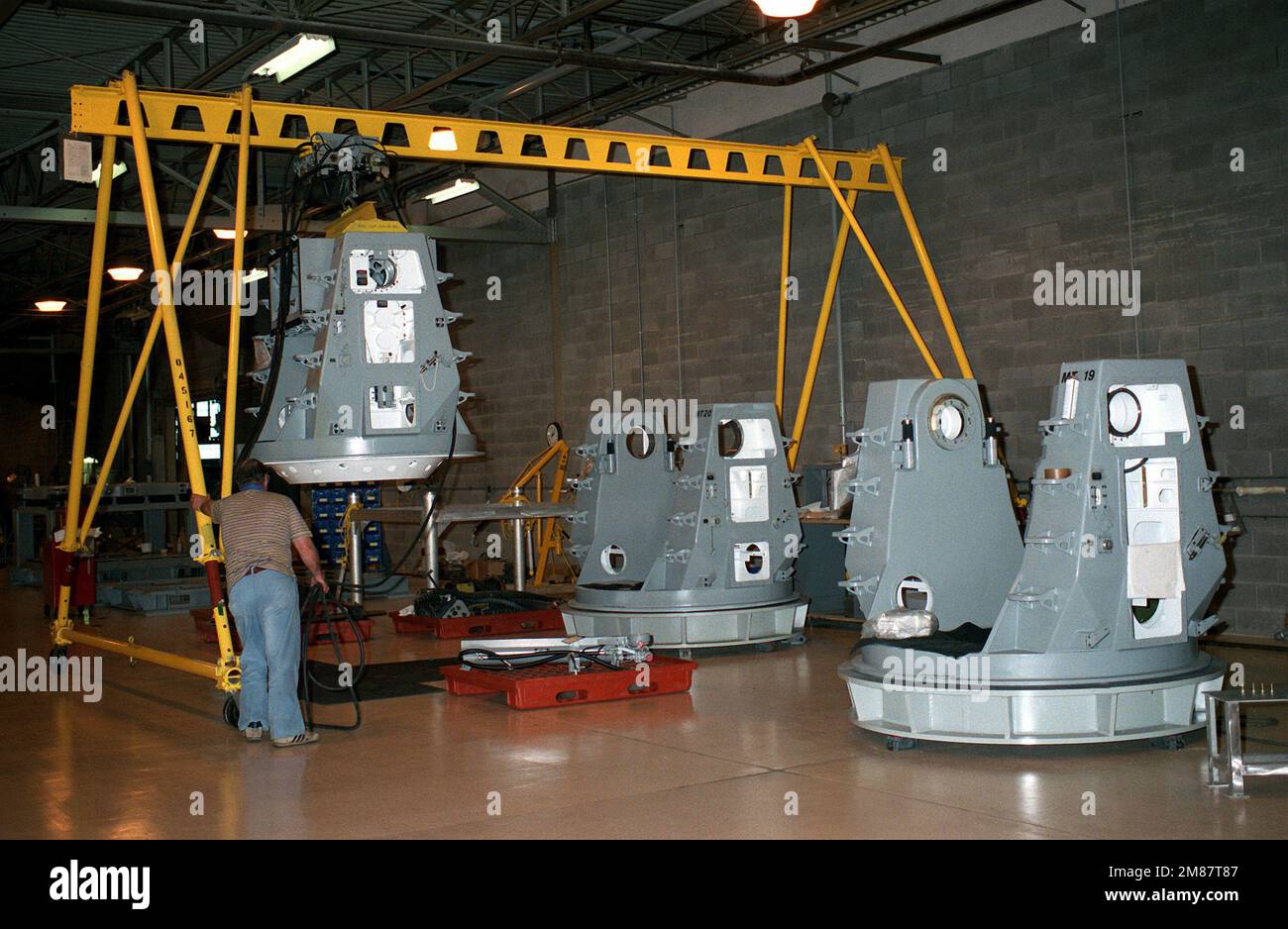 A worker uses an A-frame hoist to move one of three Mark 16 Phalanx ...