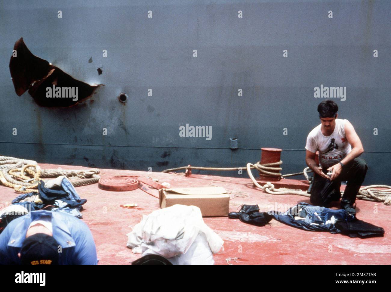 A sailor takes a break during repair operations to the guided missile ...