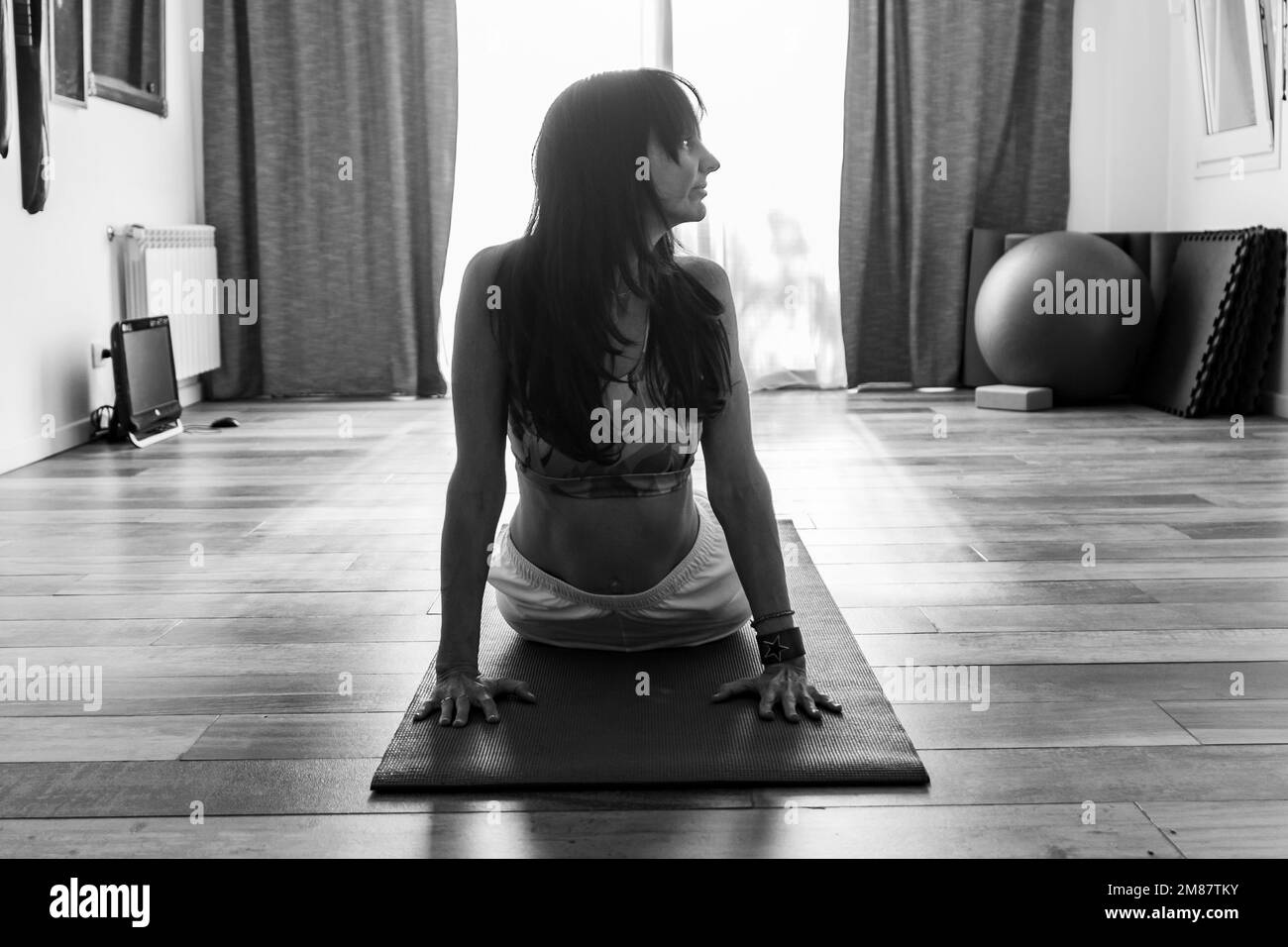 Front view of a woman practicing yoga, doing upward-facing dog exercise ...