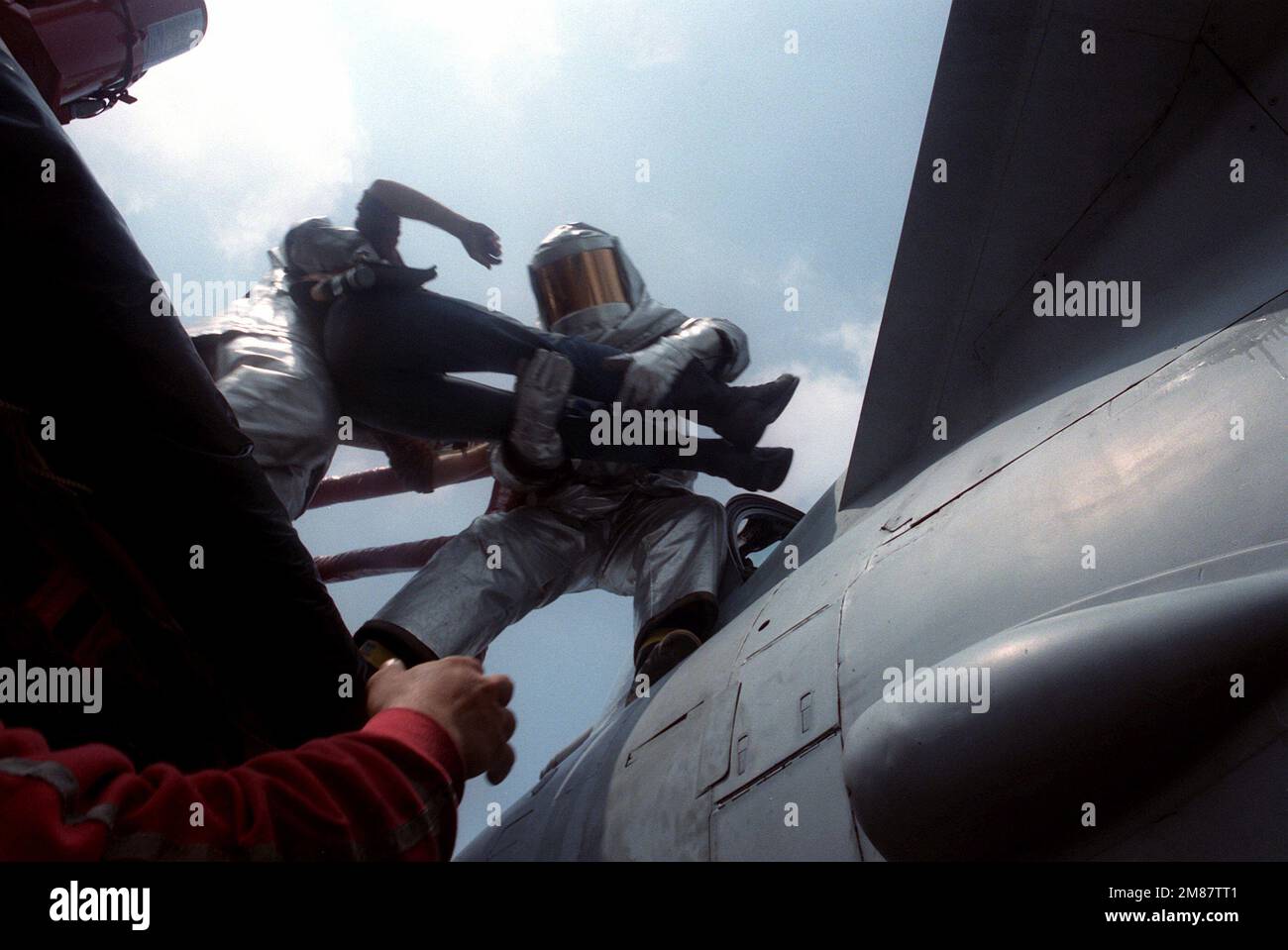 Crash and salvage team members simulate removing an injured pilot from ...