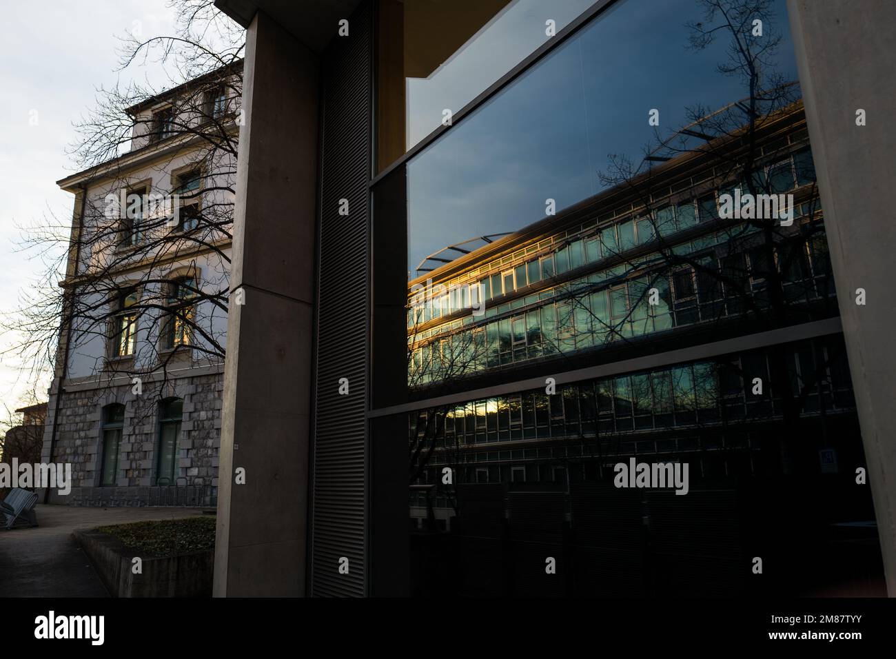 The reflection of a building on the front window of another modern ...